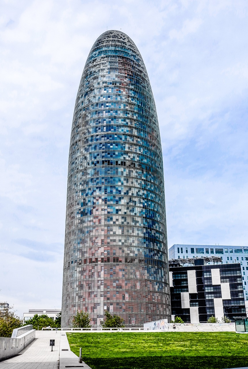 Torre Glories tower in Barcelona photographed from below against blue sky