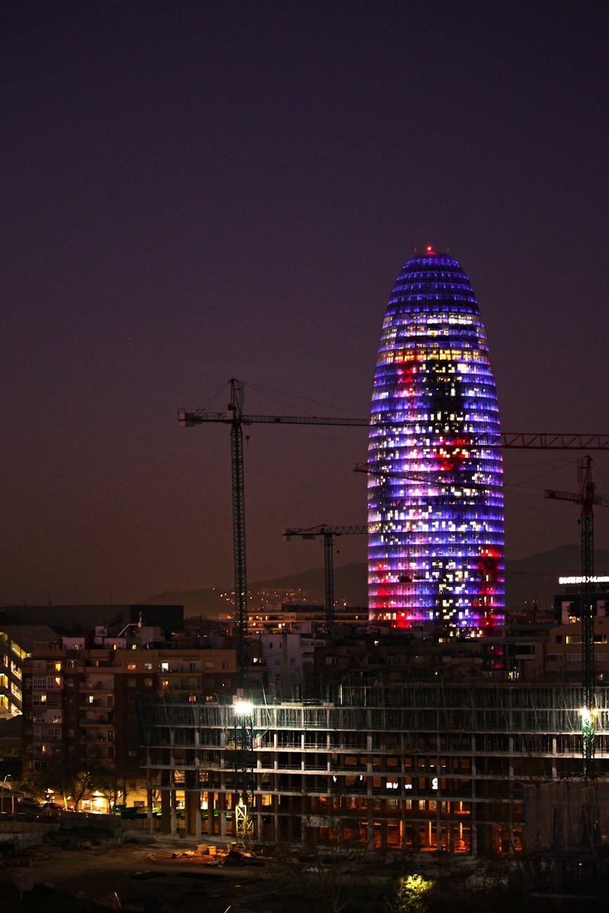 Torre Glories tower lit up in the evening Barcelona skyline