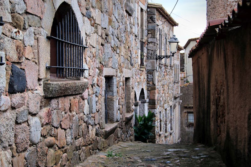 Narrow stone-walled alley inside the walled old town of Tossa de Mar on the Costa Brava