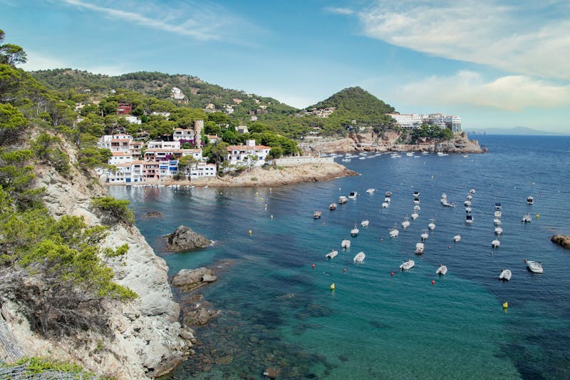 Scenic view of Tossa de Mar coastline with turquoise water and historic buildings