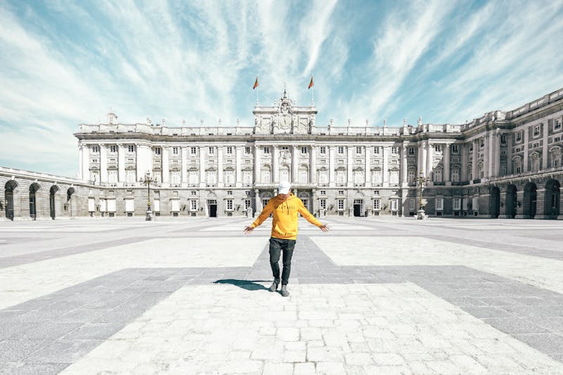 A tourist standing on the empty plaza near the Royal Palace of Madrid