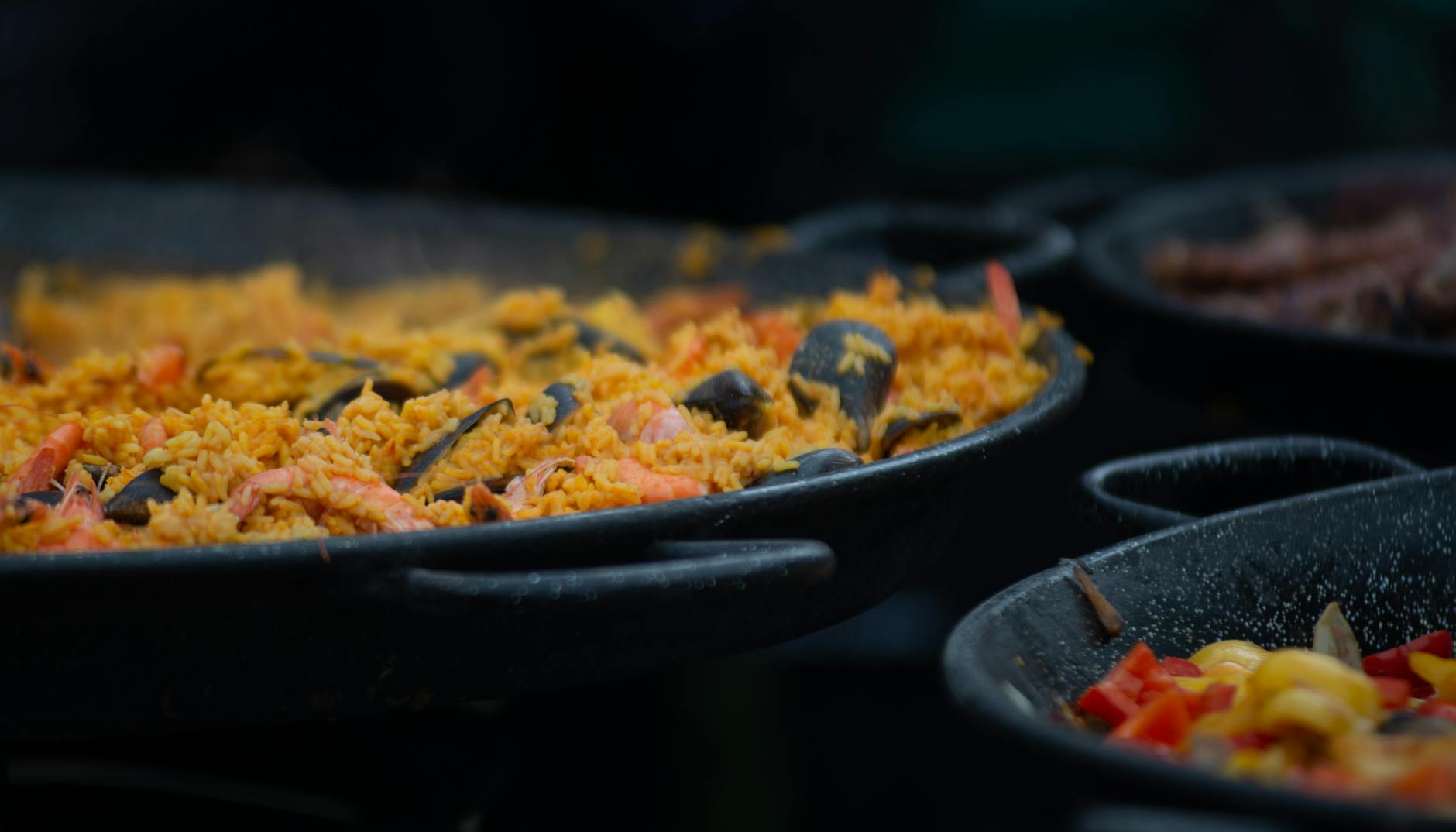 Traditional seafood paella cooking in a large outdoor pan