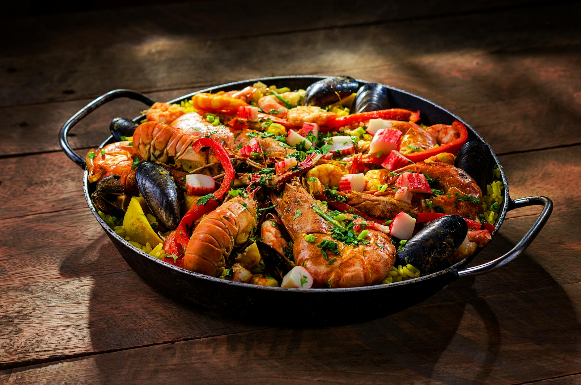 Traditional paella with shrimp and mussels in a wide pan