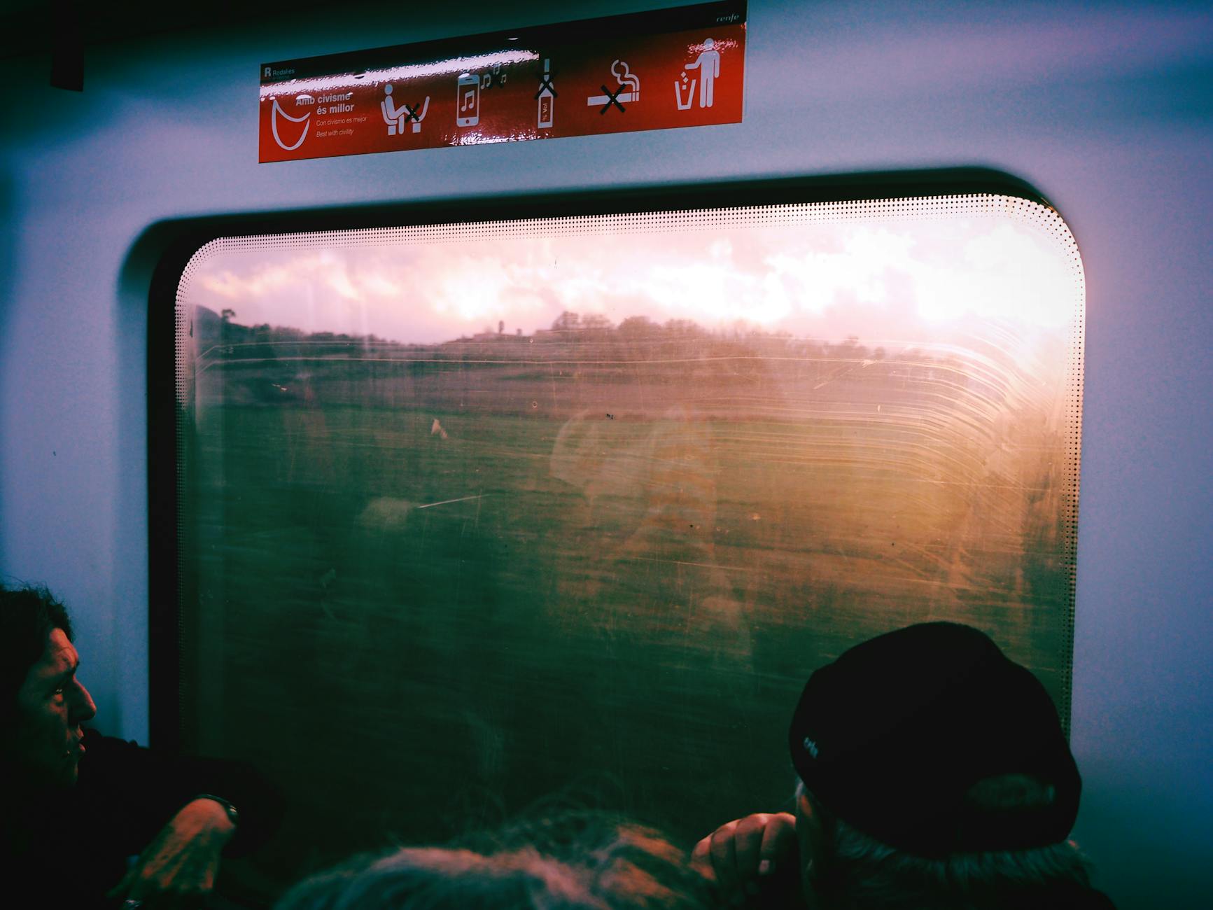 View through a train window showing the Catalan countryside with green hills