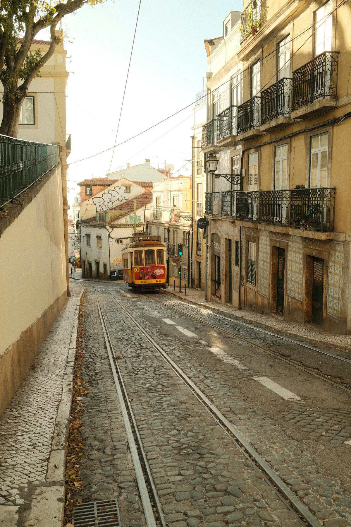 Vintage tram on Lisbon cobblestone streets with traditional buildings on both sides