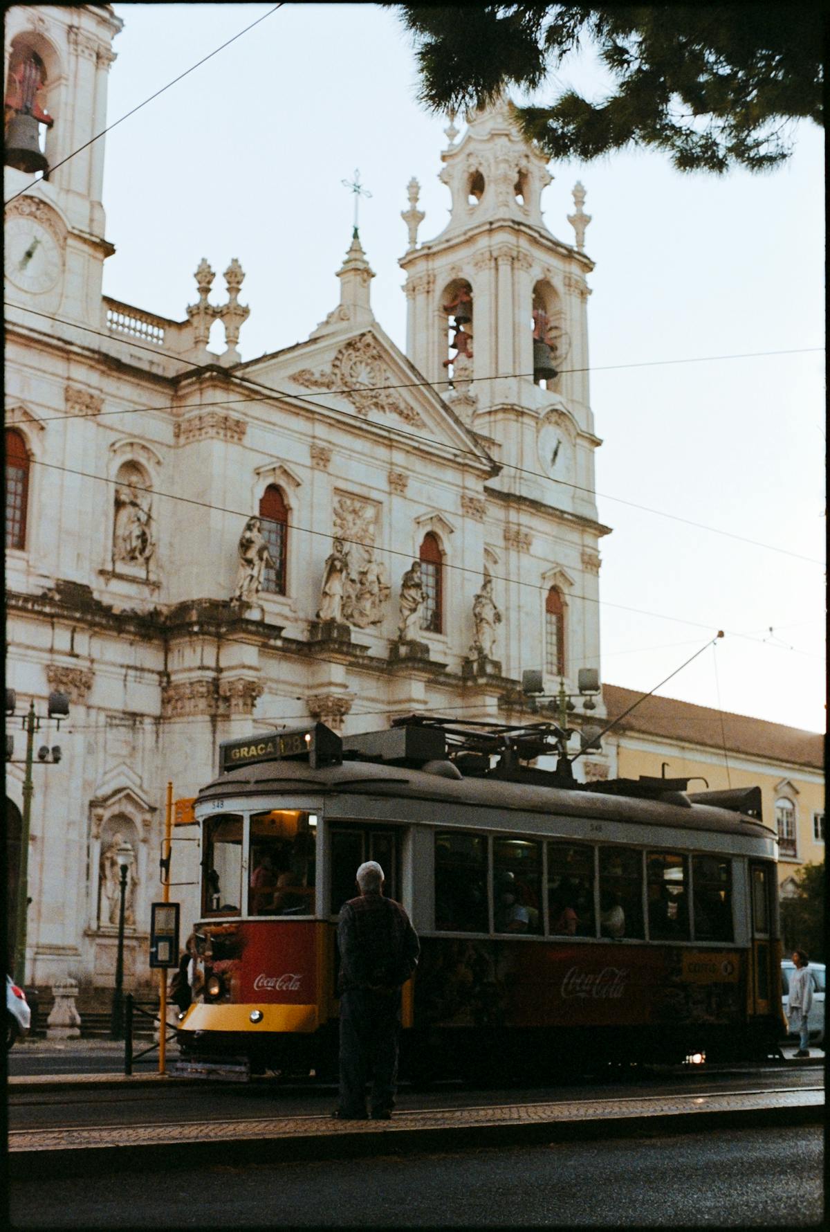 Vintage tram passing the Estrela Basilica in Lisbon on a sunny day