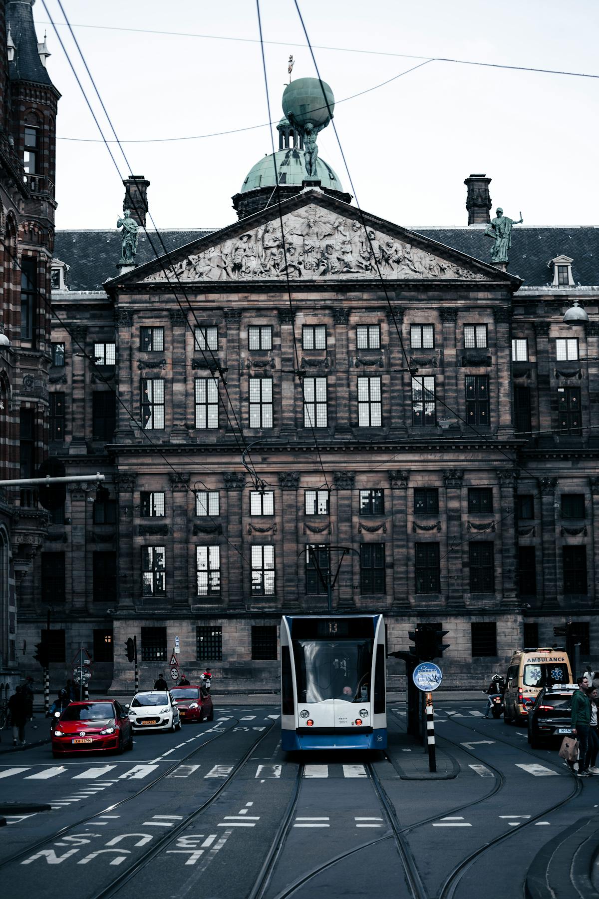 A tram passes in front of the historic Royal Palace on Dam Square in Amsterdam