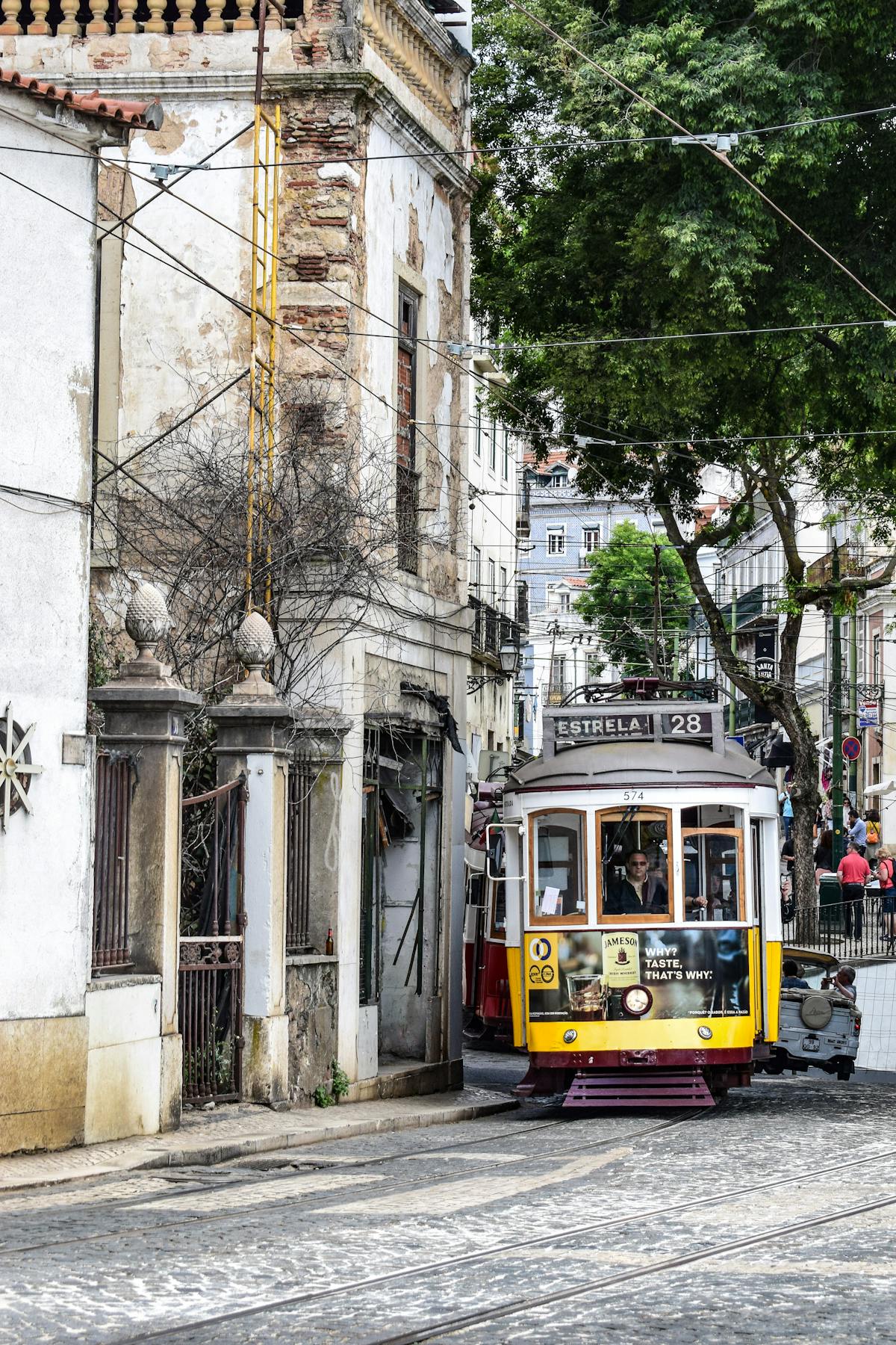 Classic Lisbon tram navigating through old streets with traditional Portuguese architecture