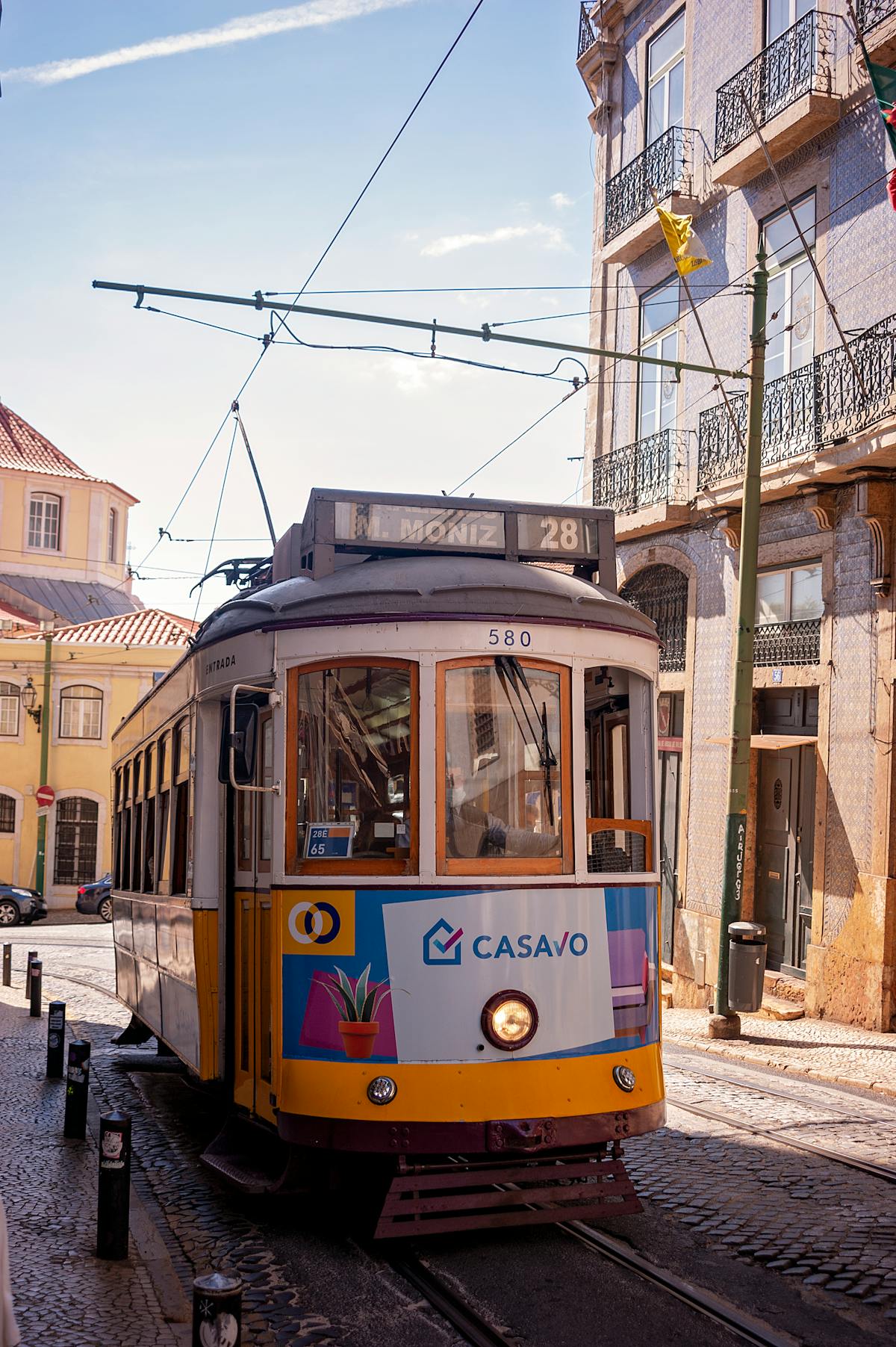 Tram 28 passing through Lisbon streets showcasing the city old-world character