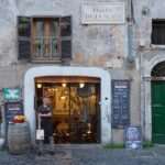 A charming restaurant entrance with wooden doors and warm lighting in Trastevere, Rome