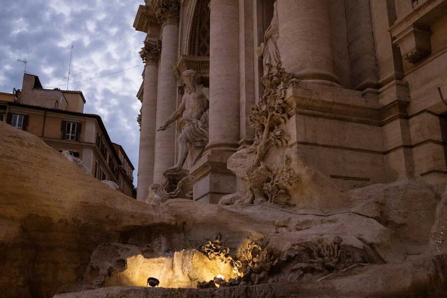 Low angle view of the Trevi Fountain showing detailed Baroque sculptures and flowing water