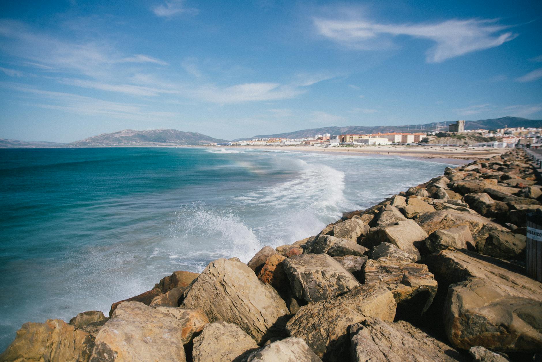 Turquoise bay of sea washing rocky coast against blue sky in southern Spain