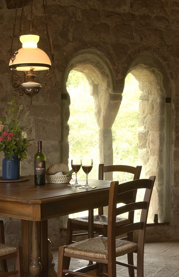 A stone farmhouse agriturismo building in the Tuscan countryside with green surroundings