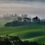 A Tuscan farmhouse surrounded by misty rolling hills in the countryside outside Florence