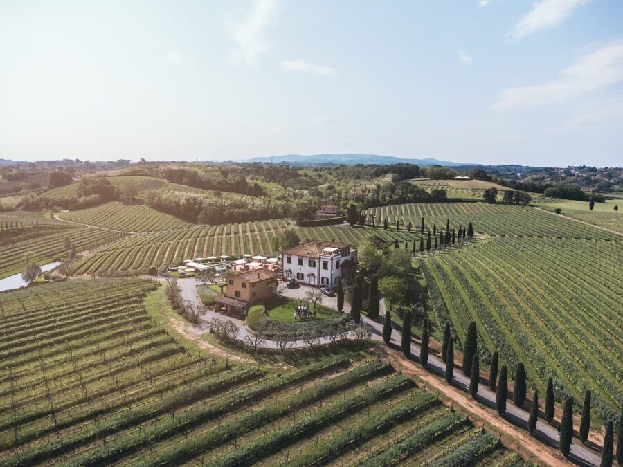 Aerial view of a villa amidst rolling vineyards in Tuscany