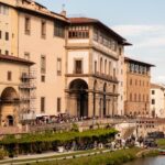 The Uffizi Gallery building stretching along the Arno River in Florence on a clear day