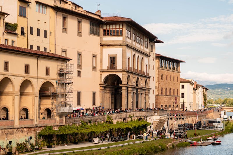 The Uffizi Gallery building stretching along the Arno River in Florence on a clear day