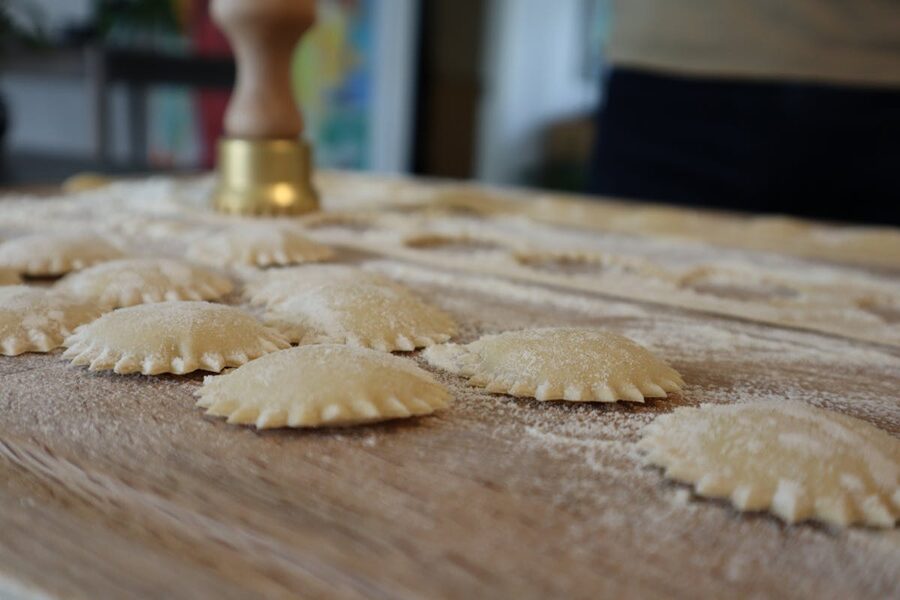 Close-up of rows of uncooked ravioli on a floured board ready for cooking