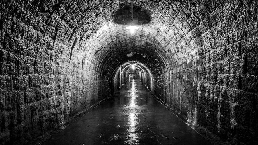 Atmospheric stone walled tunnel with dramatic lighting similar to underground passages