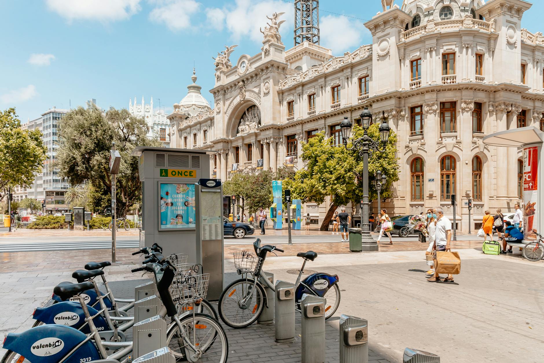 City street in Valencia, Spain with bicycles for rent near a historic building.