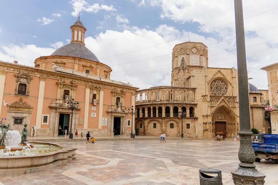 Wide view of Valencia Cathedral and Plaza de la Virgen with a historical stone archway