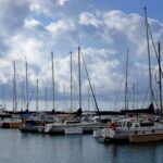 Sailboats moored at a marina in Valencia Spain under a cloudy Mediterranean sky