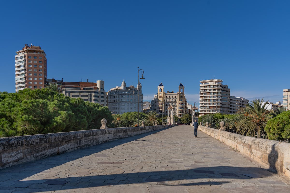 Valencia skyline viewed from a historic stone bridge on a clear sunny day