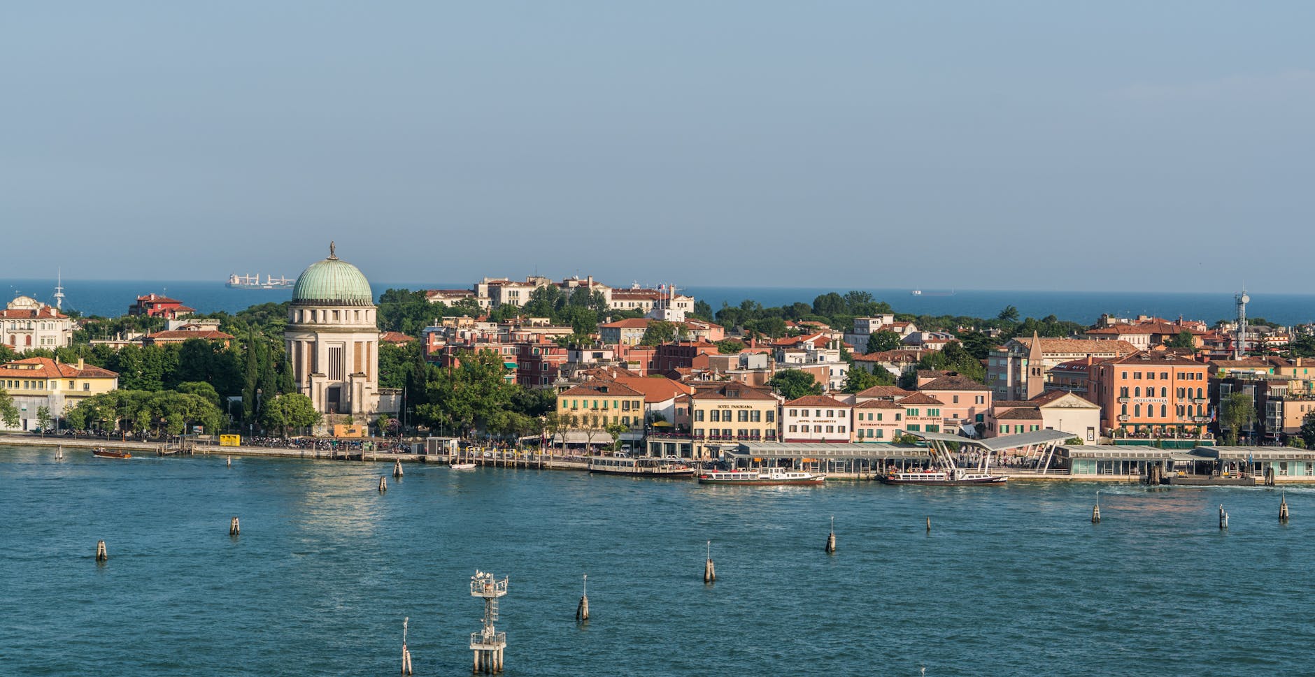 Venetian architecture along a serene waterfront under clear blue skies