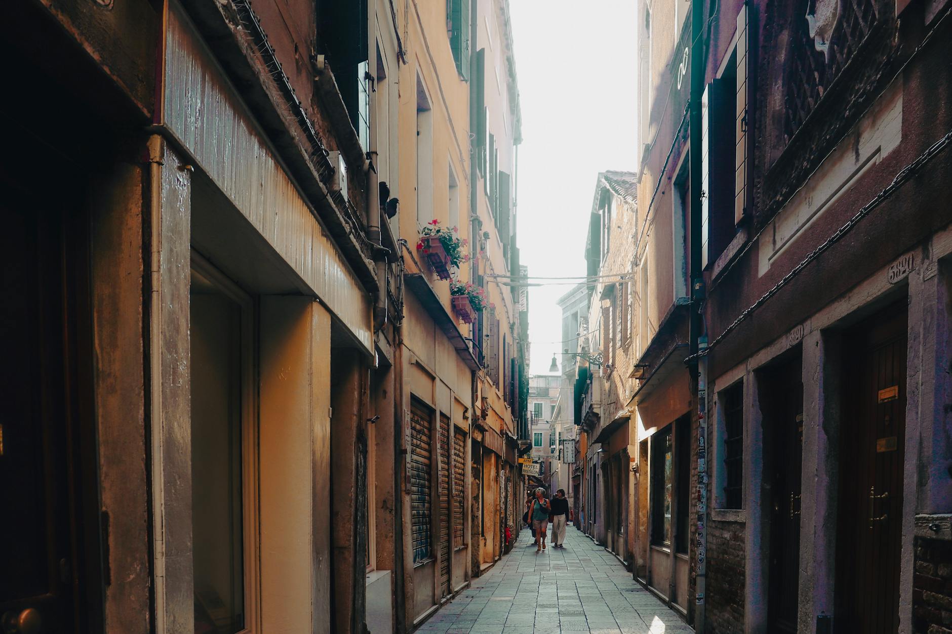 A picturesque alleyway in Venice with warm sunlight and historic architecture