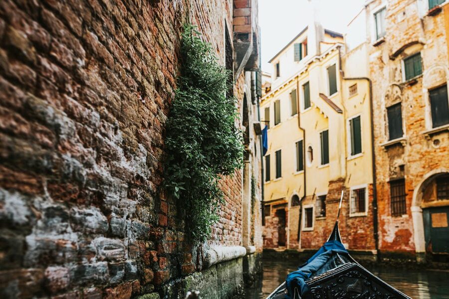 A gondola glides through a narrow Venice canal surrounded by historic buildings
