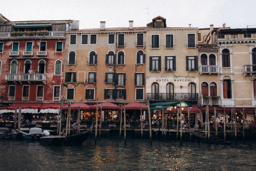 Colorful historic buildings lining a Venice canal with gondolas moored along the waterway