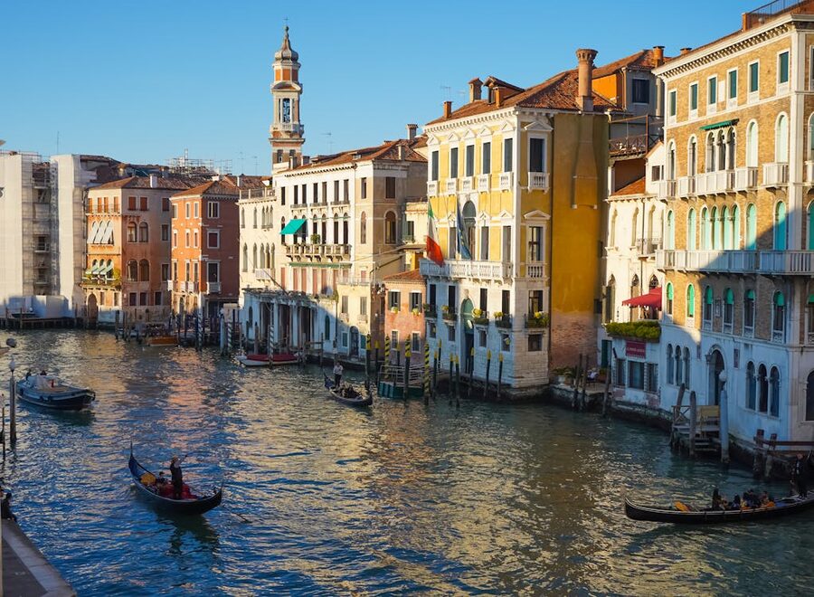 Row of gondolas moored along a historic Venice canal with buildings reflected in the water