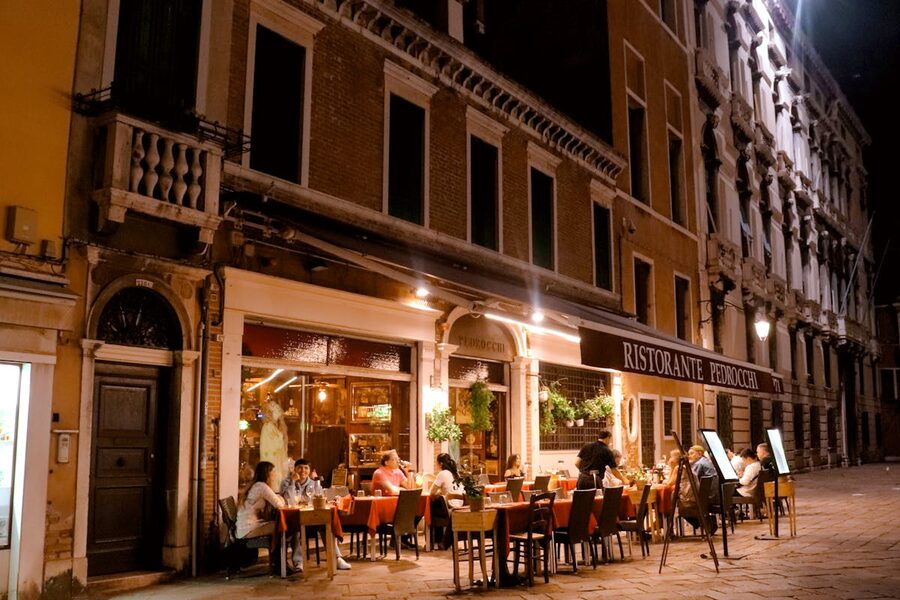Diners enjoying an evening meal at a canalside restaurant in Venice