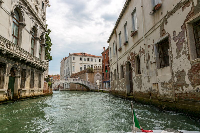 Venetian canal with a stone bridge and historic architecture on a cloudy day