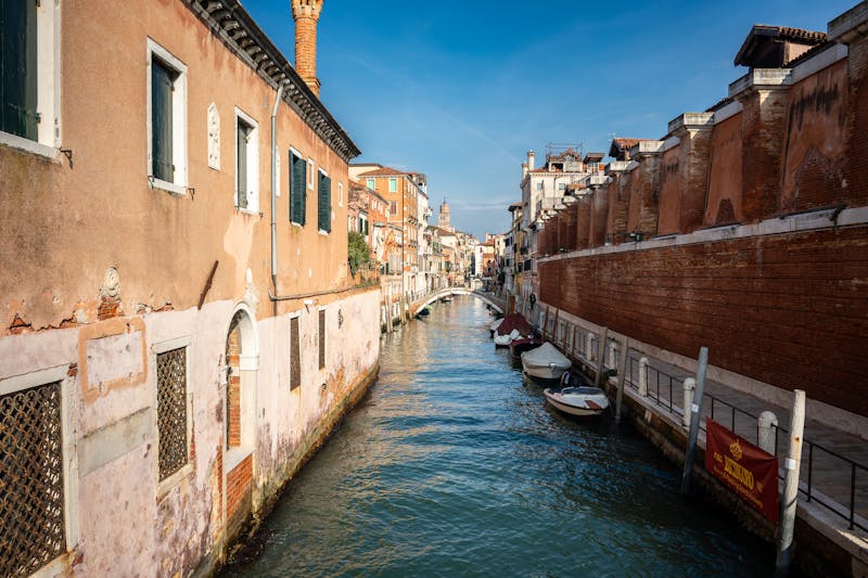 Scenic view of a Venetian canal flanked by historic buildings on a sunny day