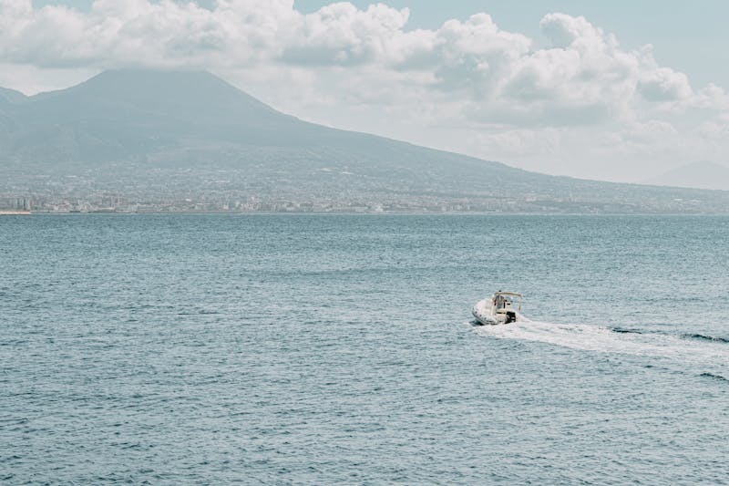Motorboat on the sea with Mount Vesuvius visible in the background near Naples
