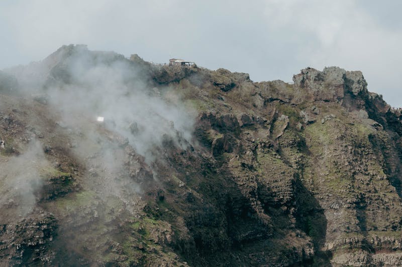Close-up view of the rugged terrain of Mount Vesuvius crater with clouds surrounding the summit
