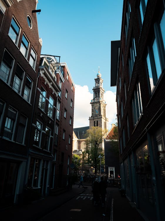View of the Westerkerk tower framed between traditional Amsterdam buildings