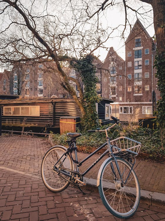 Vintage bicycle parked on an Amsterdam street with traditional Dutch houses in background