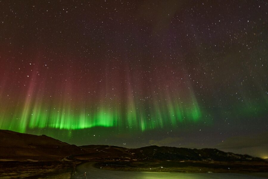 Vivid aurora borealis dancing over Ãžingeyjarsveit, Iceland's dark sky.