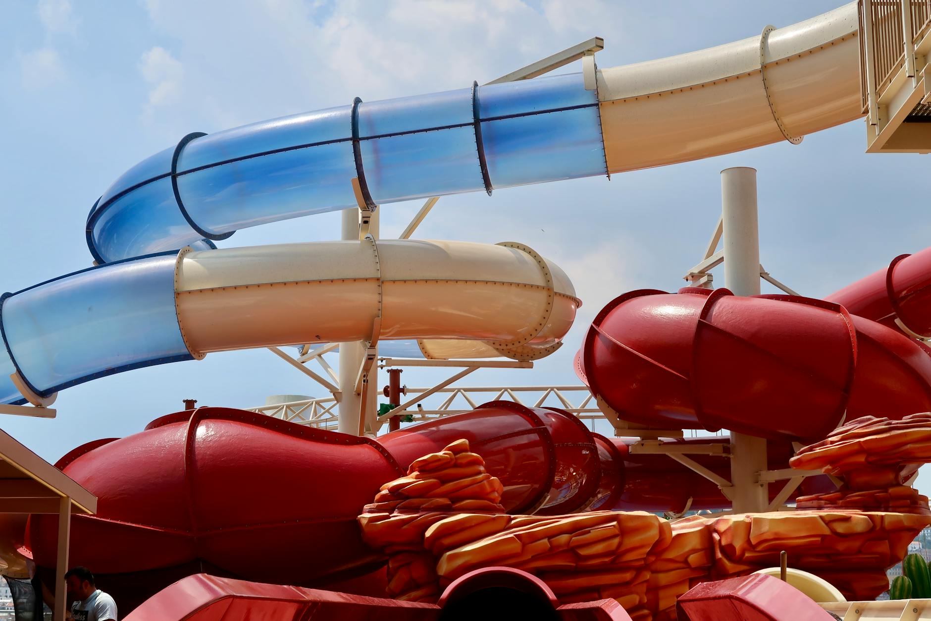 Colorful water slides at an outdoor amusement park under blue sky