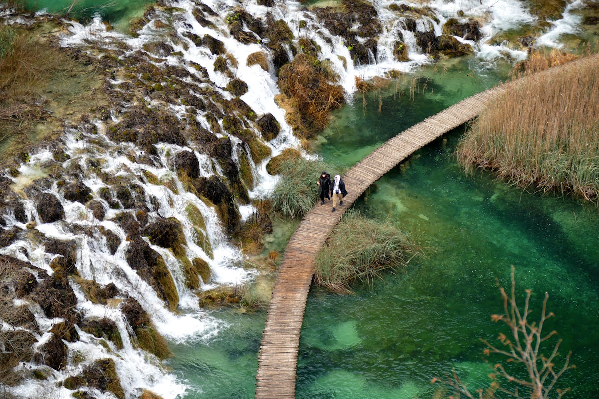 Wooden boardwalk path through waterfalls at a national park