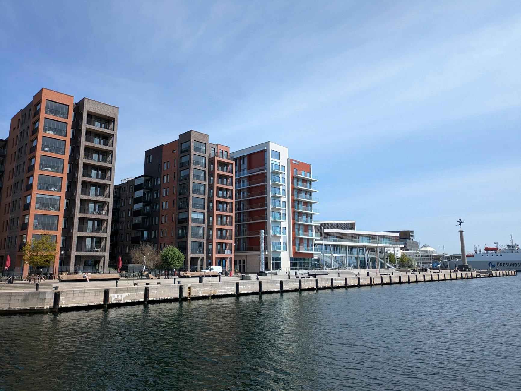 Angular modern buildings on the waterfront with blue sky and clouds