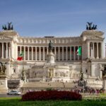 The grand white marble Vittoriano monument in Piazza Venezia Rome with Italian flags flying