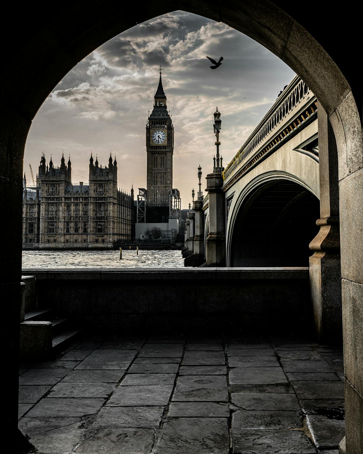 Big Ben through stone arch by River Thames