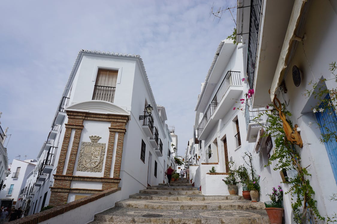 Whitewashed Spanish street with potted plants and traditional architecture
