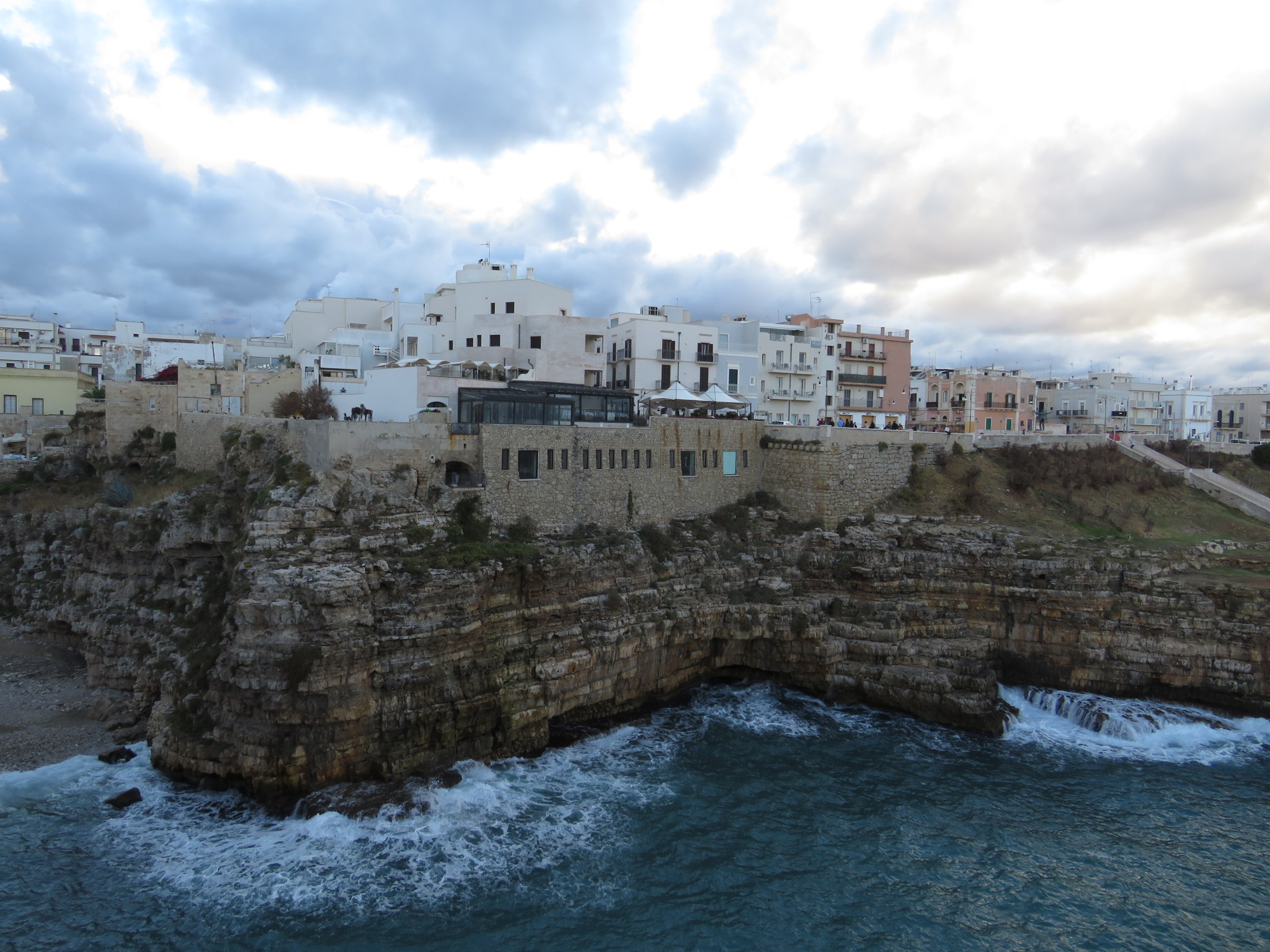 Cala Porto pebble beach surrounded by towering cliffs in Polignano a Mare