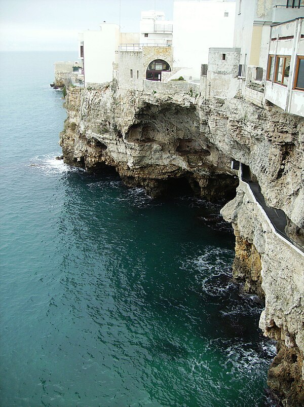 The exterior of the famous Grotta Palazzese cave restaurant in Polignano a Mare built into the cliff face