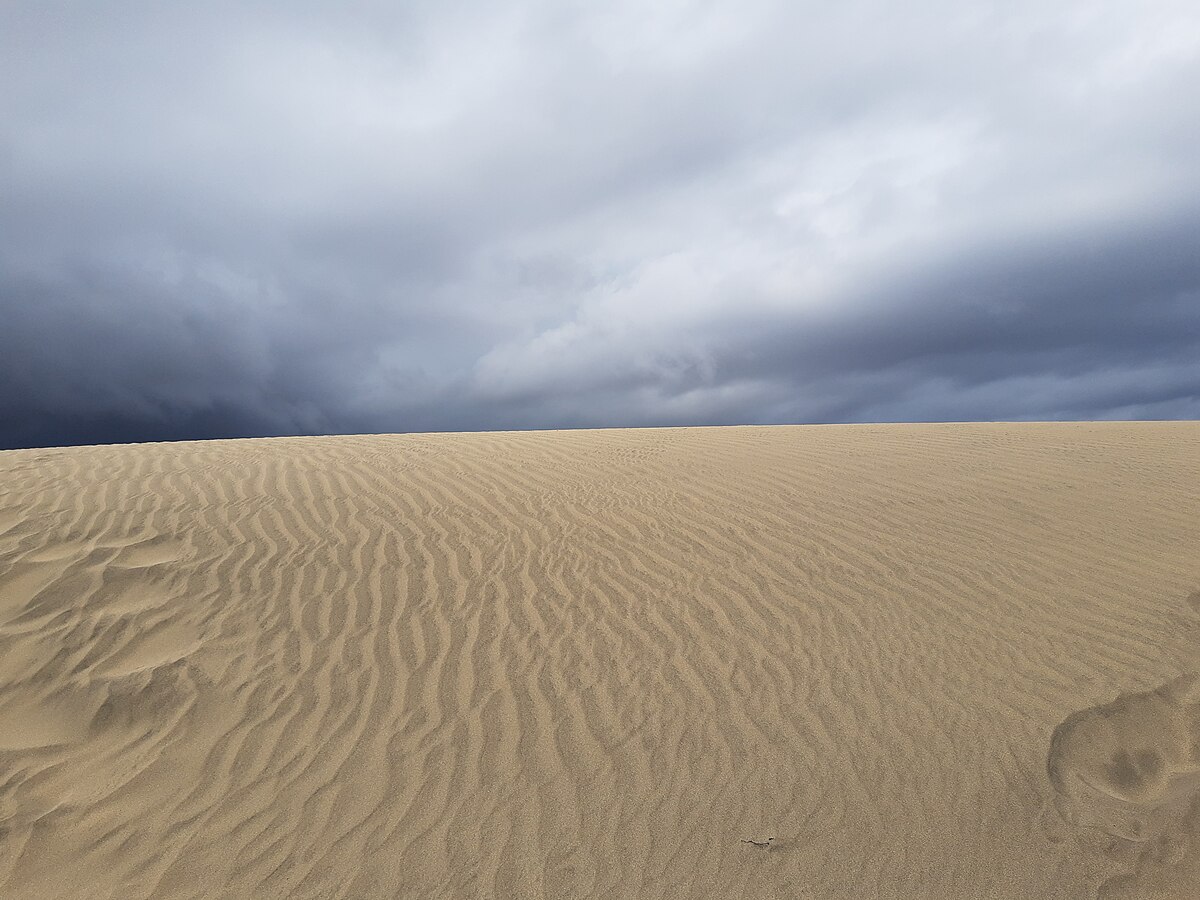 Sand patterns in the Maspalomas Dunes with dramatic clouds above Gran Canaria