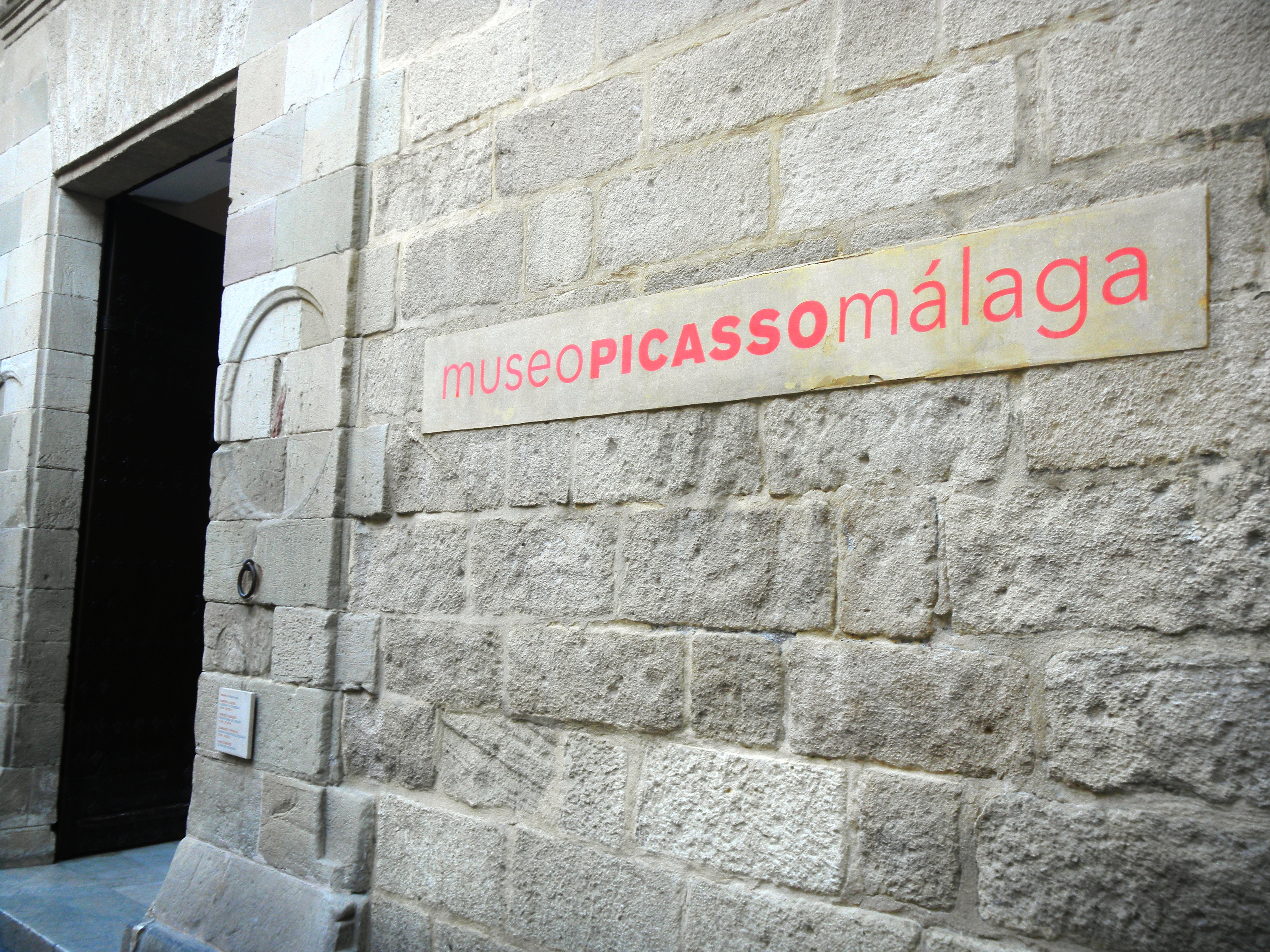 Stone entrance of the Museo Picasso Malaga showing the museum sign on the historic Palacio de Buenavista